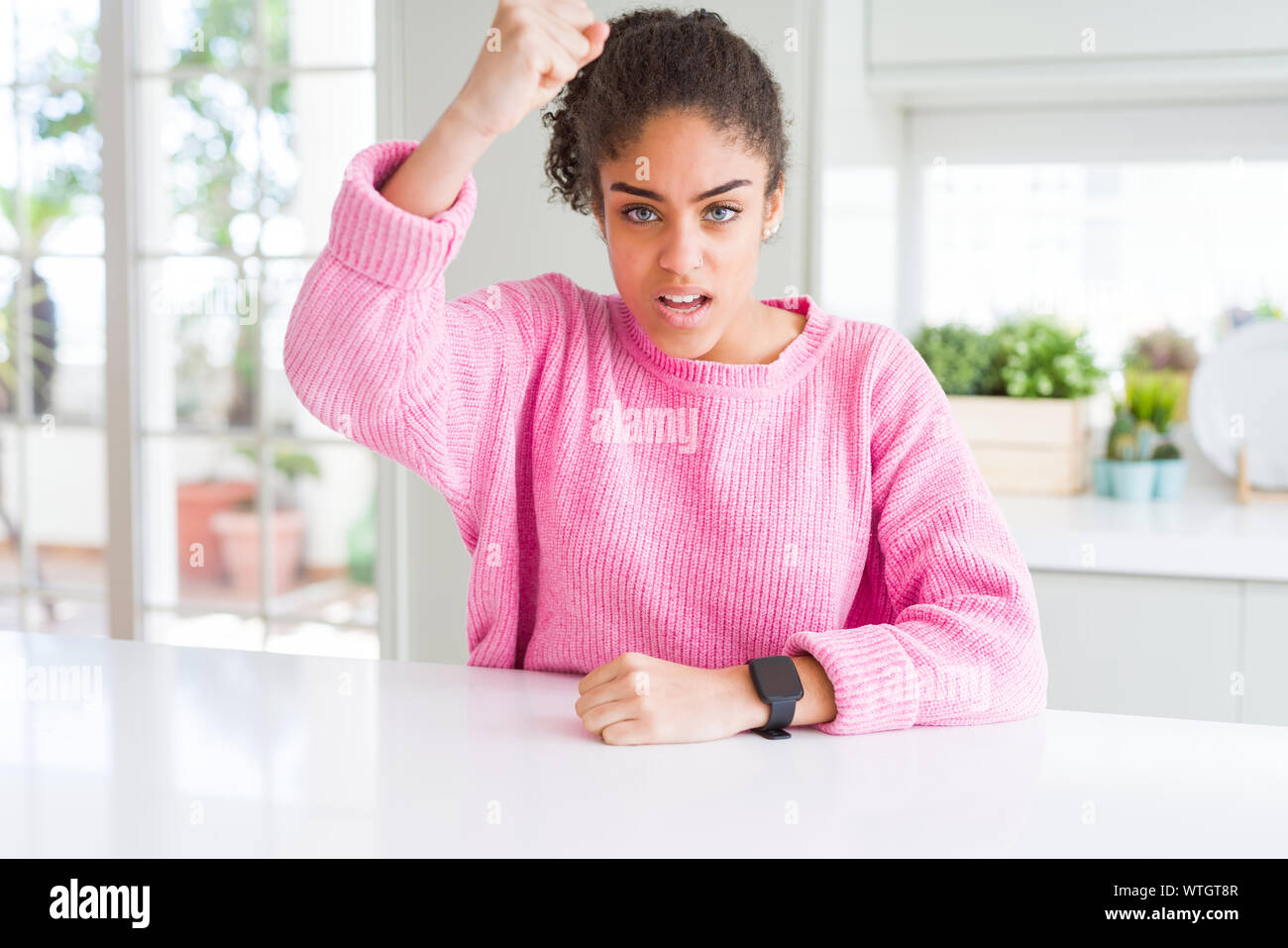 Beautiful african american woman with afro hair wearing casual pink ...