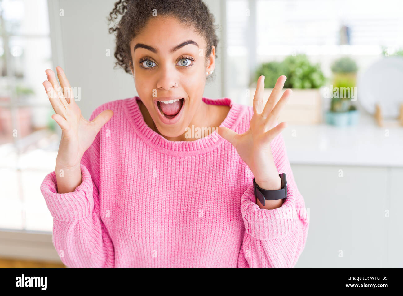 Beautiful young african american woman with afro hair celebrating crazy ...