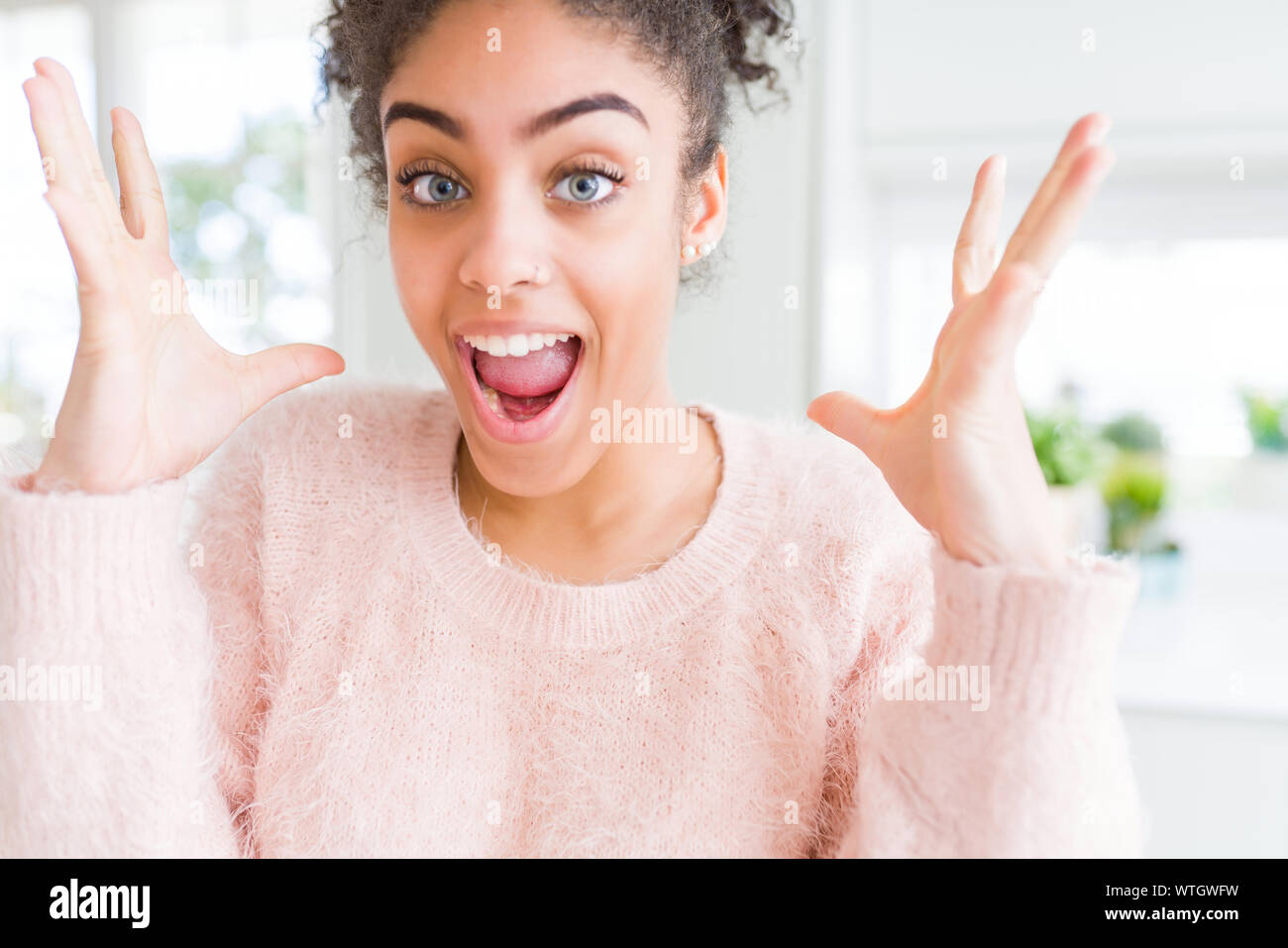 Beautiful young african american woman with afro hair celebrating crazy ...