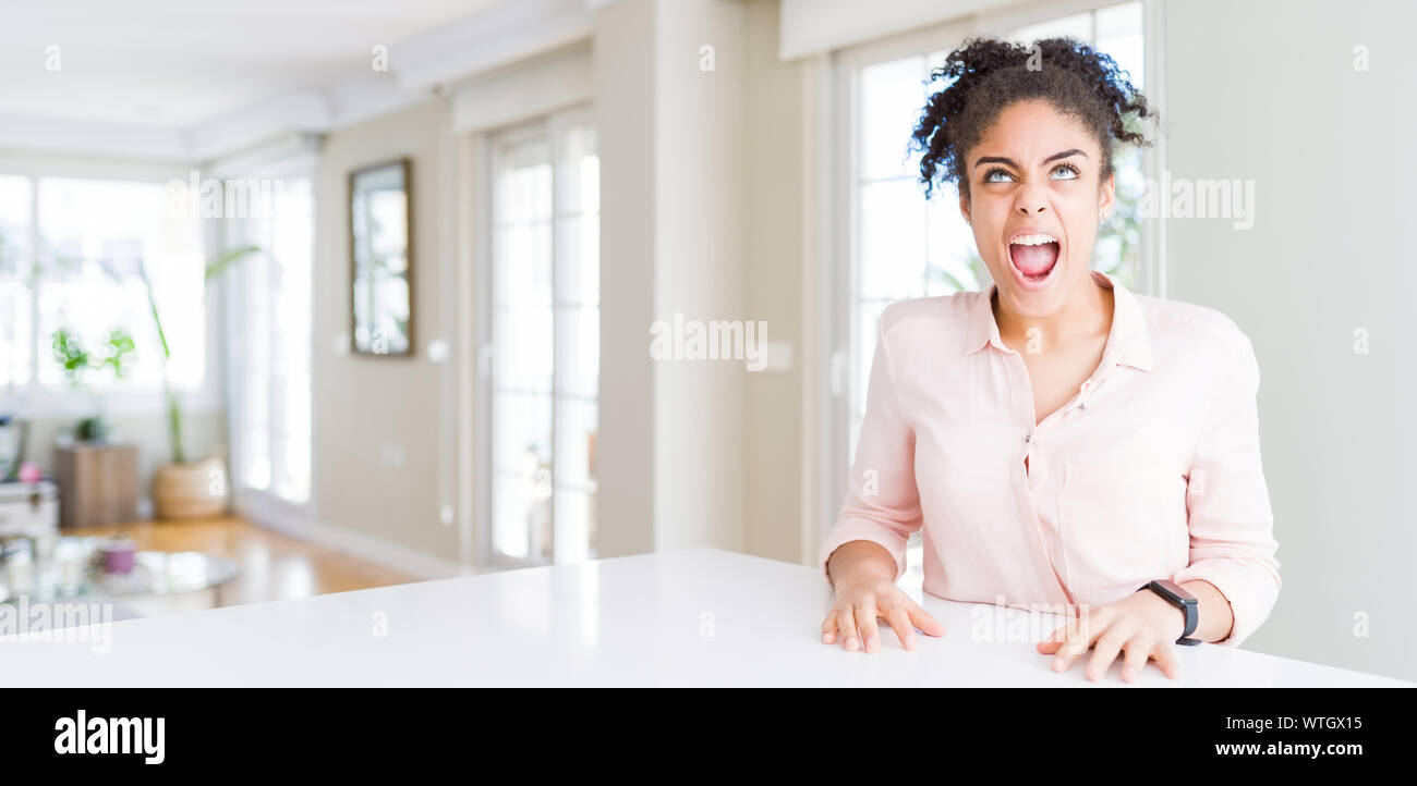 Wide angle of beautiful african american woman with afro hair angry and ...