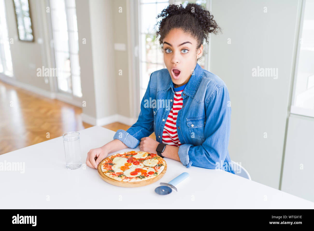 Young african american woman eating homemade mozzarella cheese pizza ...