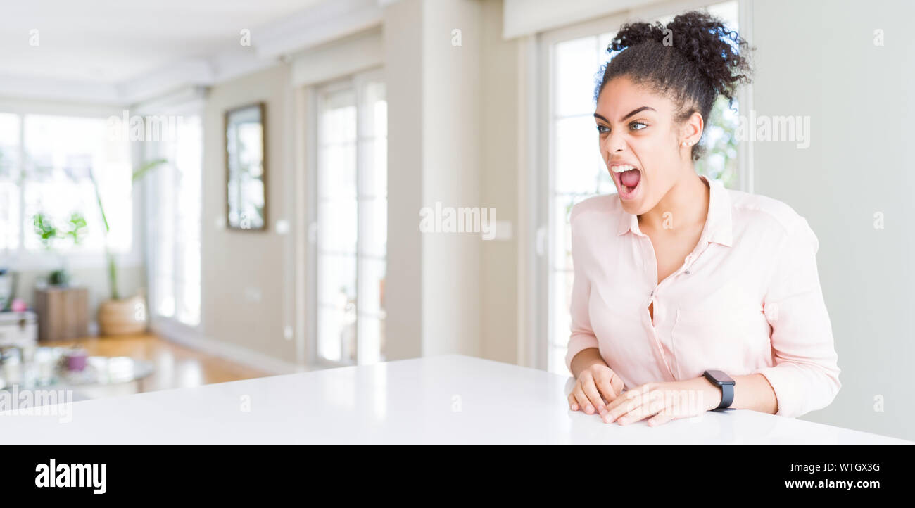 Wide angle of beautiful african american woman with afro hair angry and ...