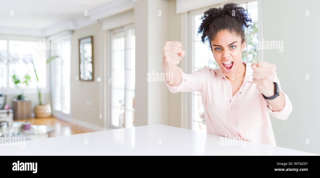 Wide angle of beautiful african american woman with afro hair angry and ...