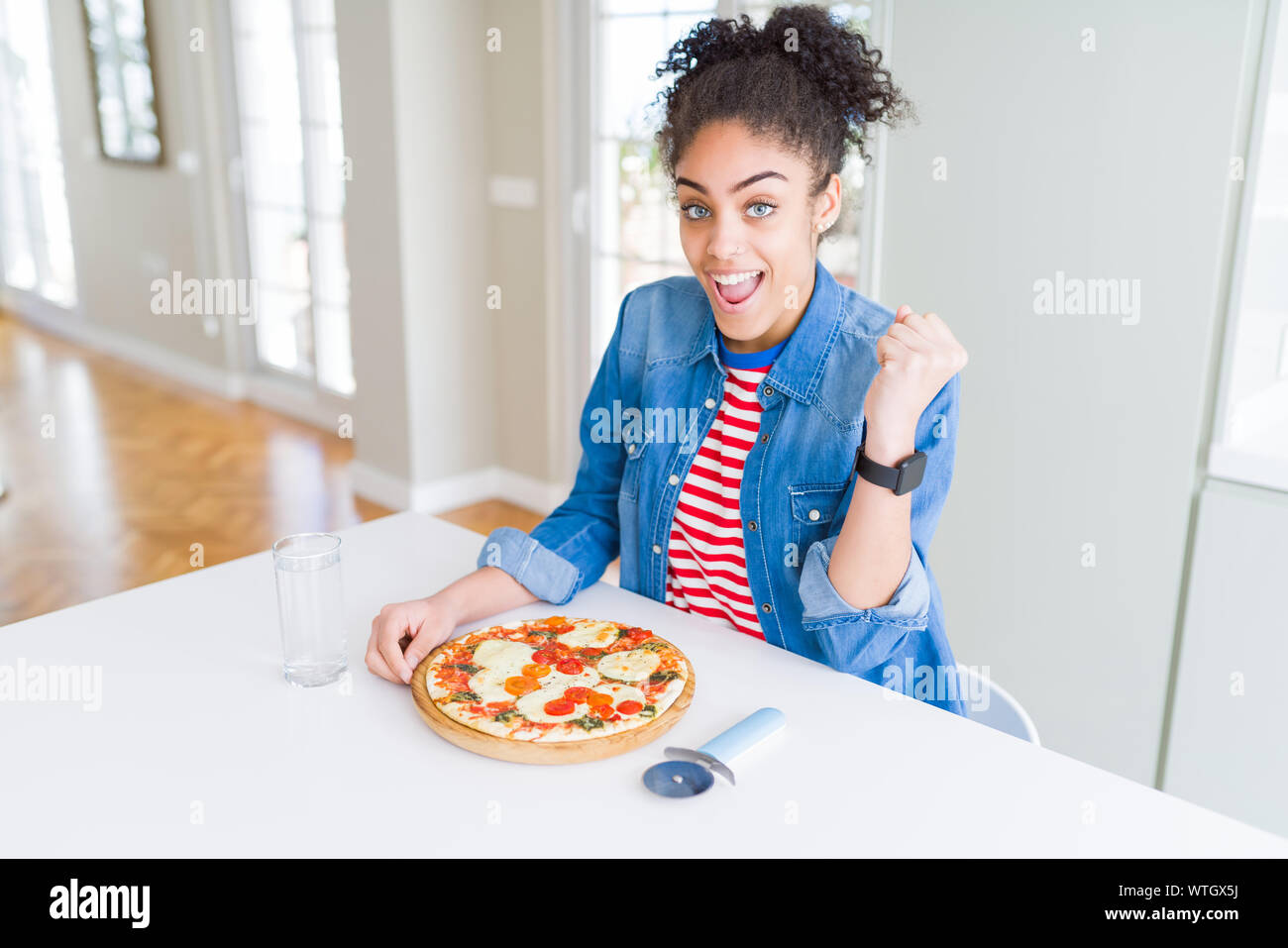 Young african american woman eating homemade mozzarella cheese pizza ...
