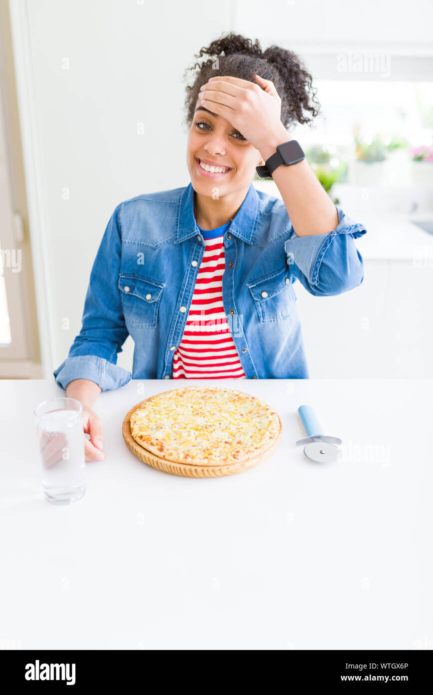 Young african american woman eating homemade cheese pizza stressed with ...