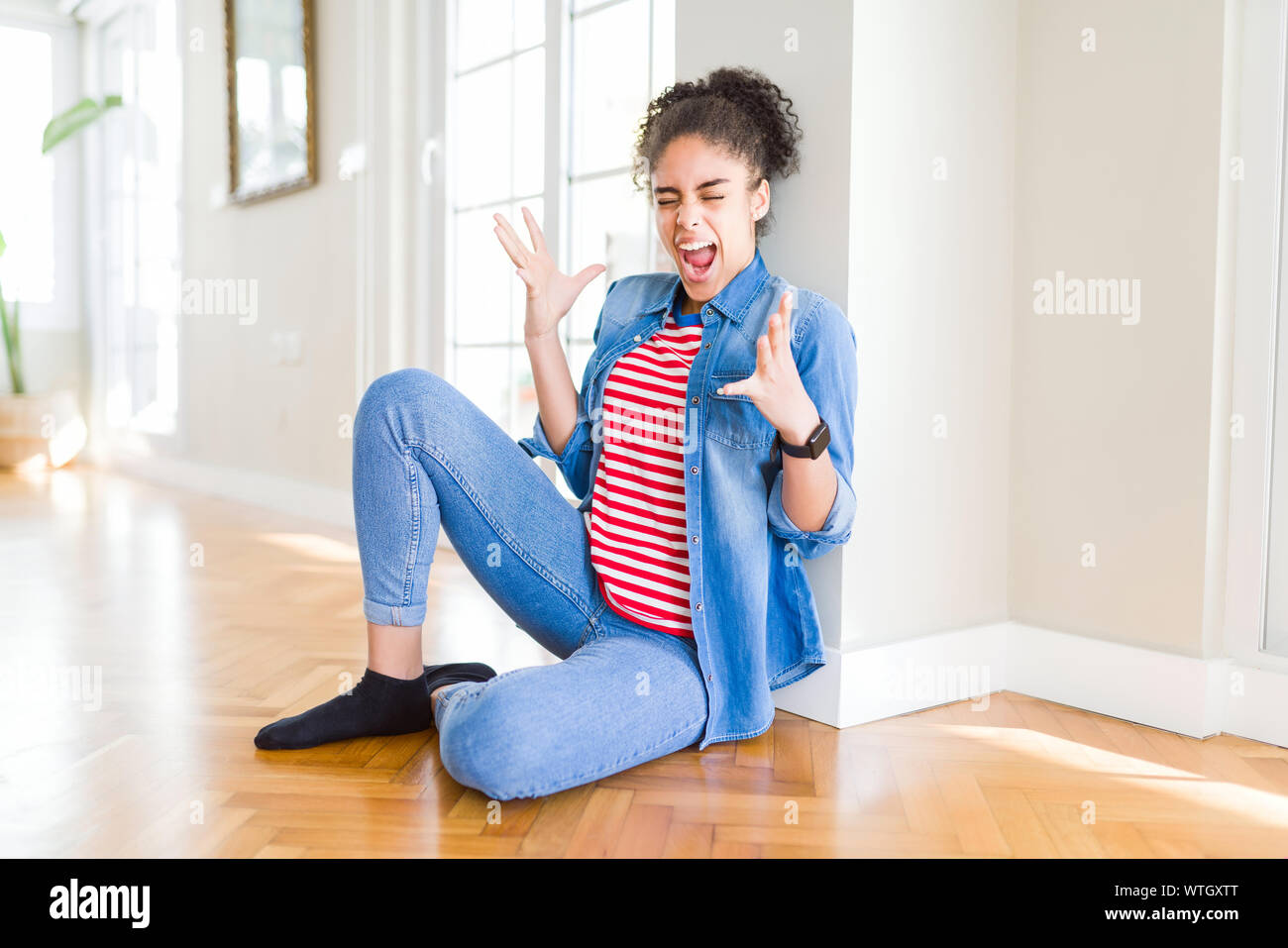 Beautiful young african american woman with afro hair sitting on the ...