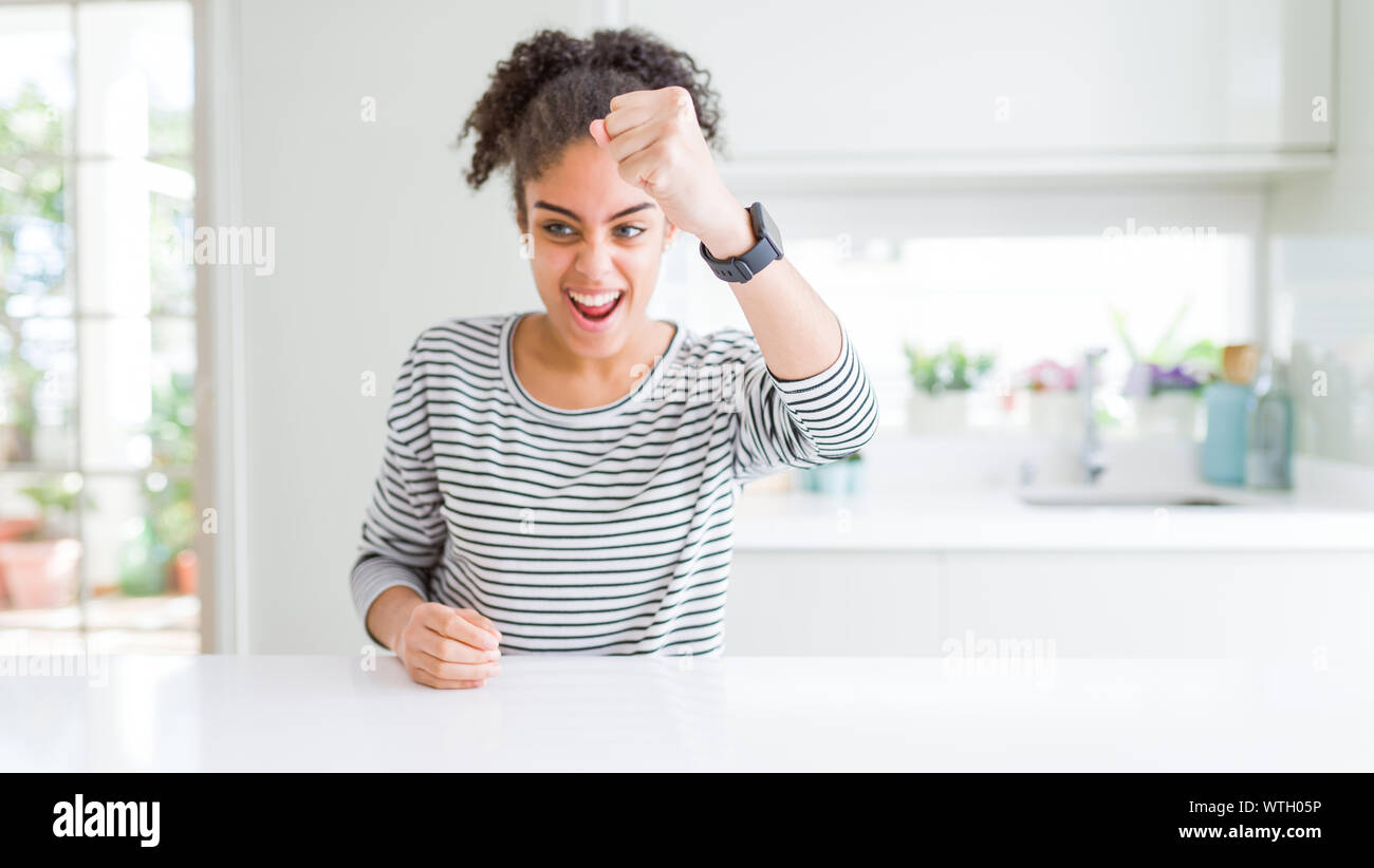 Beautiful african american woman with afro hair wearing casual striped ...