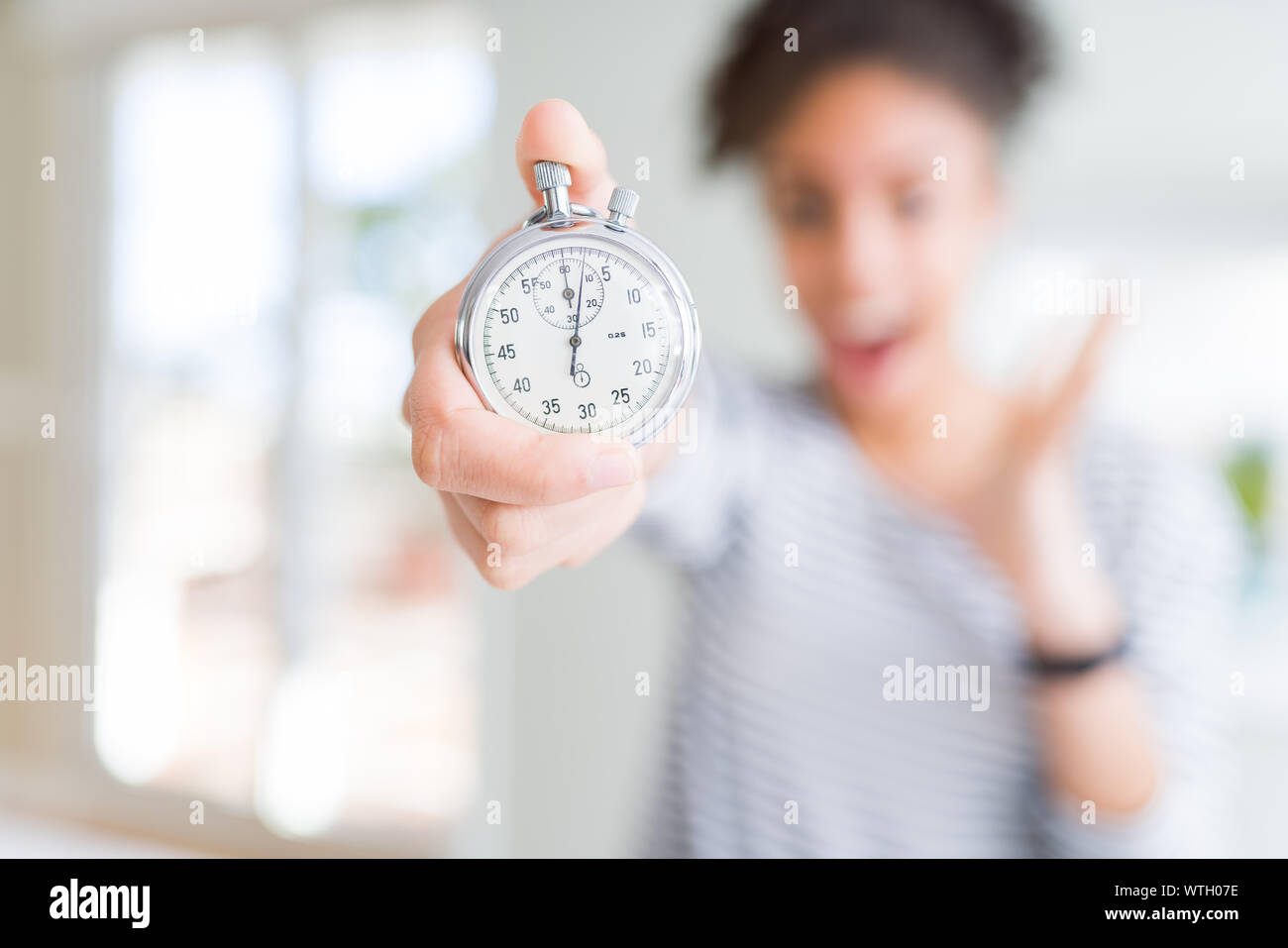 Young african american woman holding stopwatch very happy and excited ...