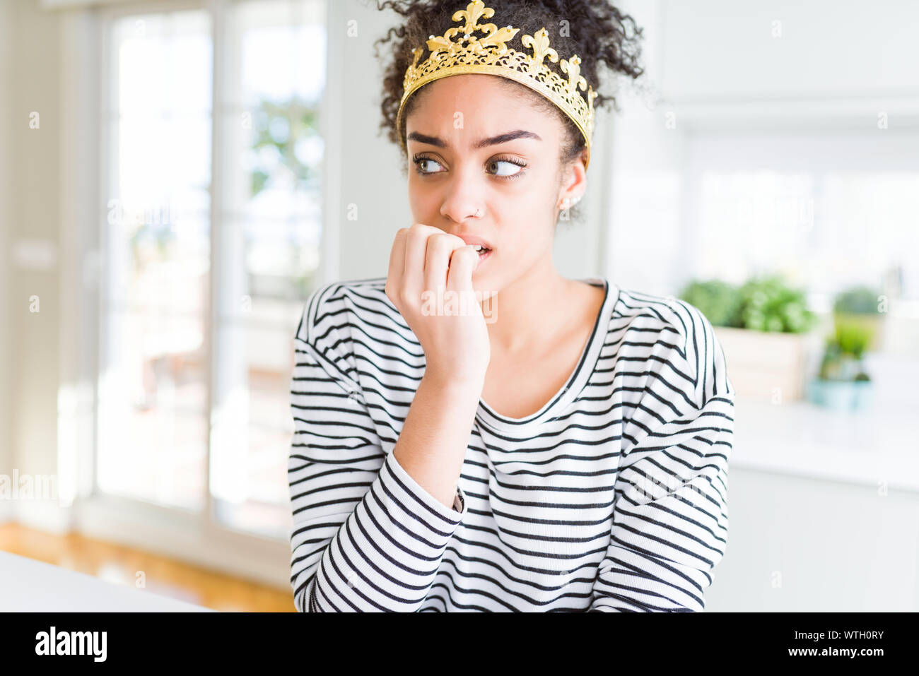 Young african american girl wearing golden queen crown on head looking ...