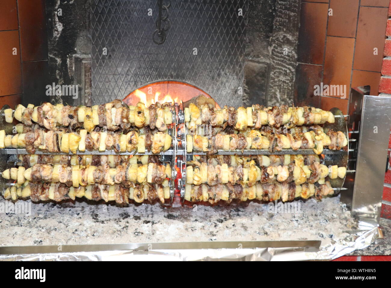 Roasted meat on spit grilled over fire Stock Photo - Alamy