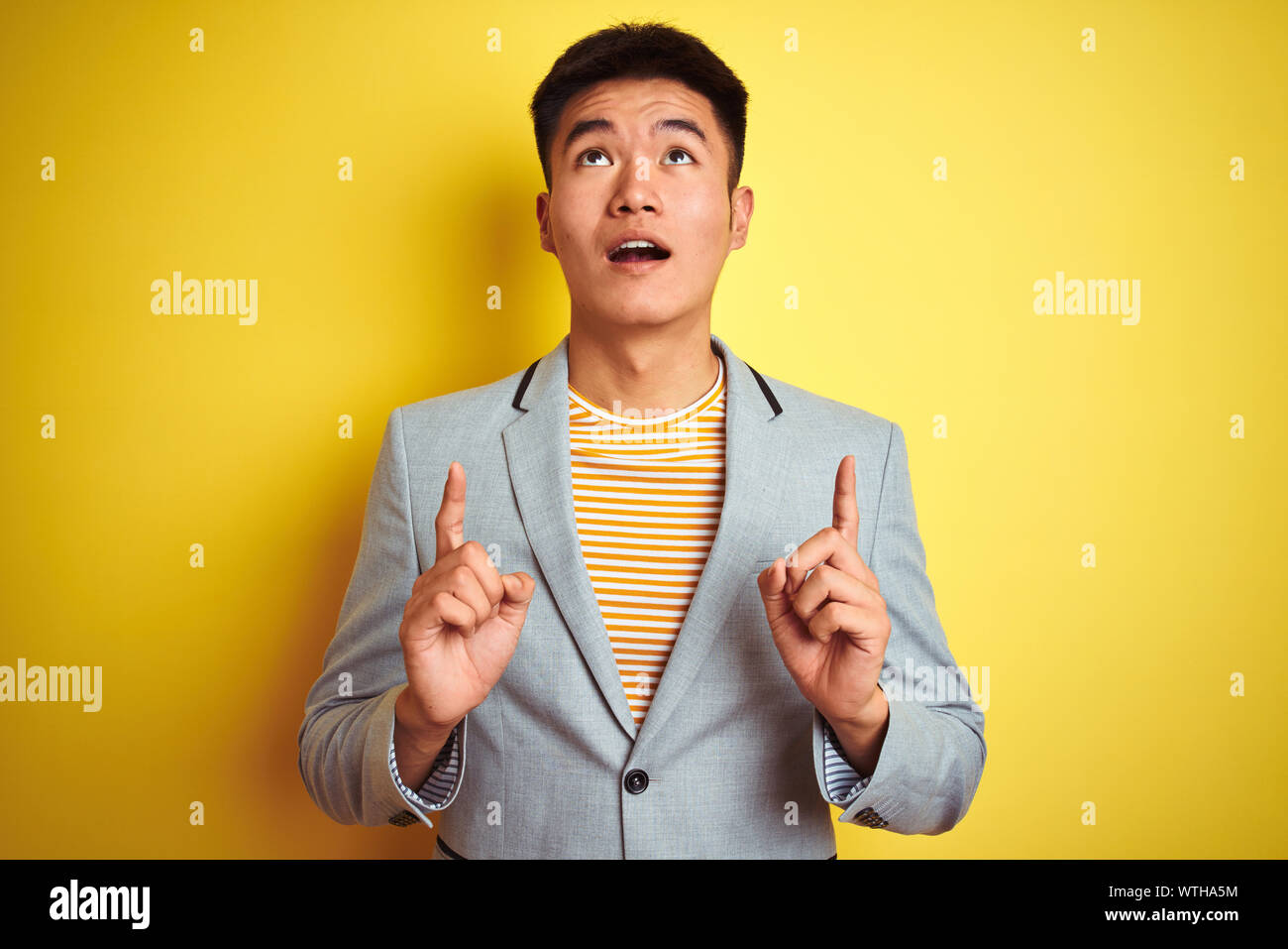 Young asian chinese businessman wearing jacket standing over isolated ...