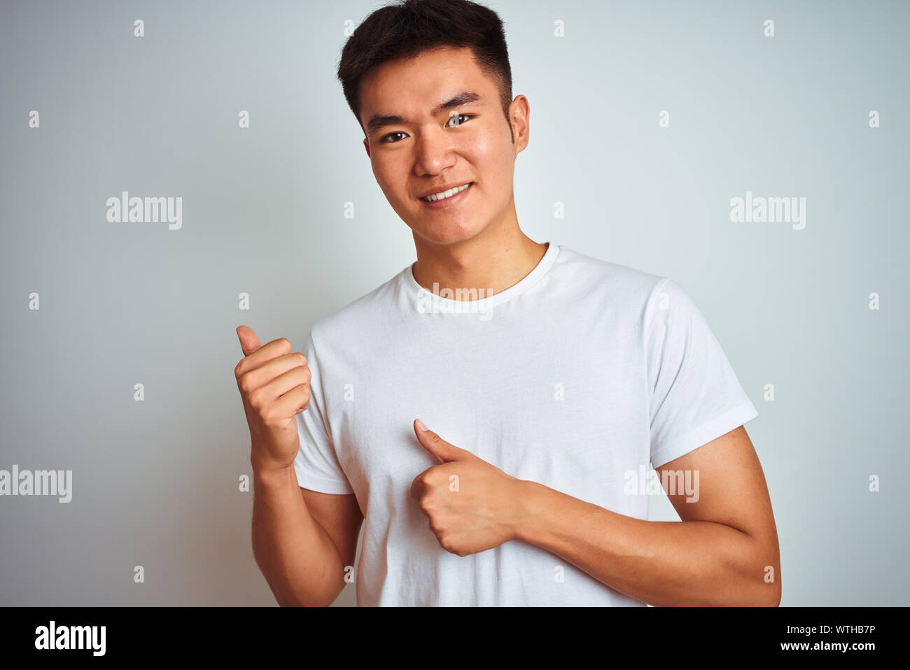 Young Asian Chinese Man Wearing T Shirt Standing Over Isolated White