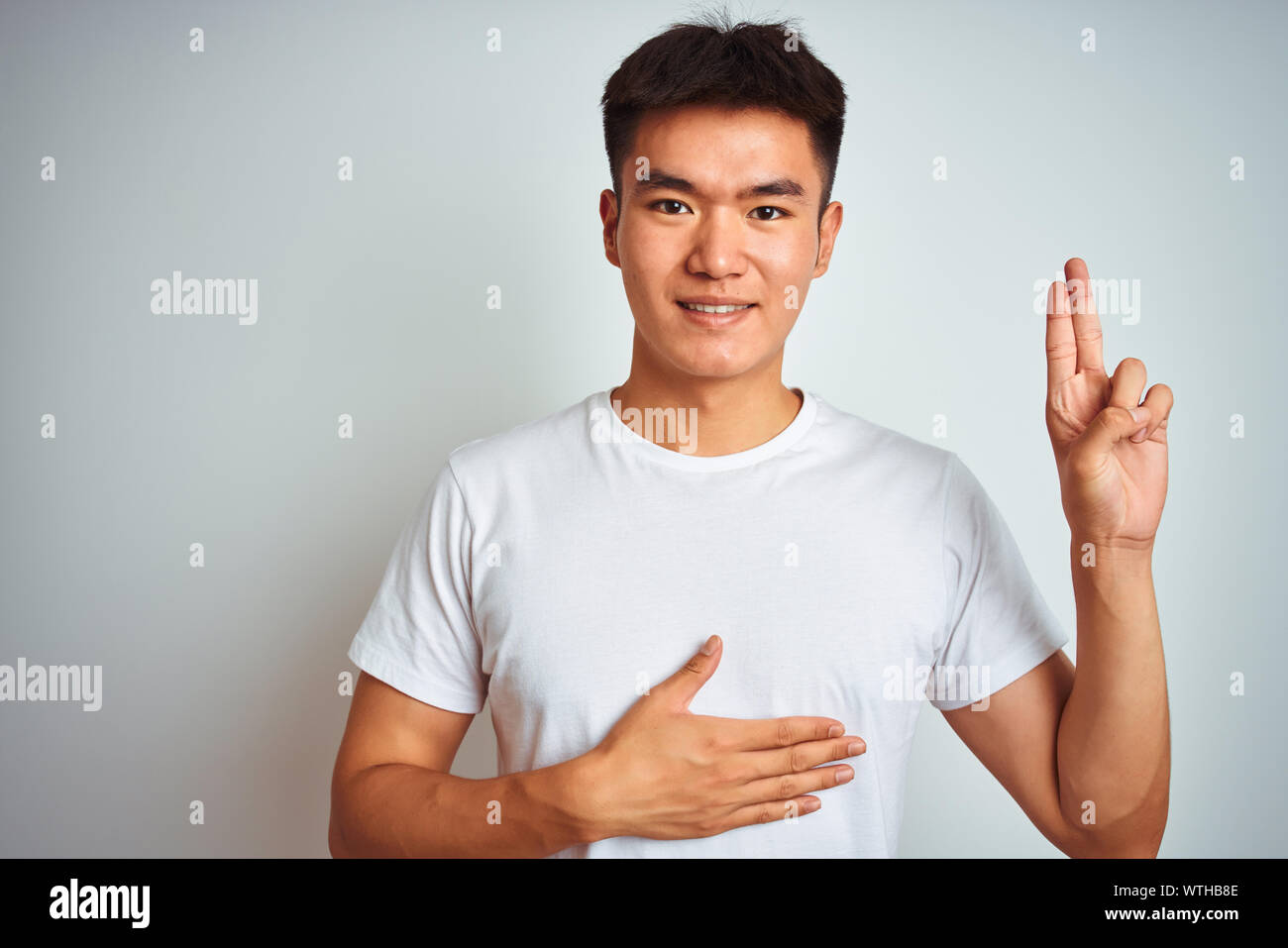 Young Asian Chinese Man Wearing T Shirt Standing Over Isolated White