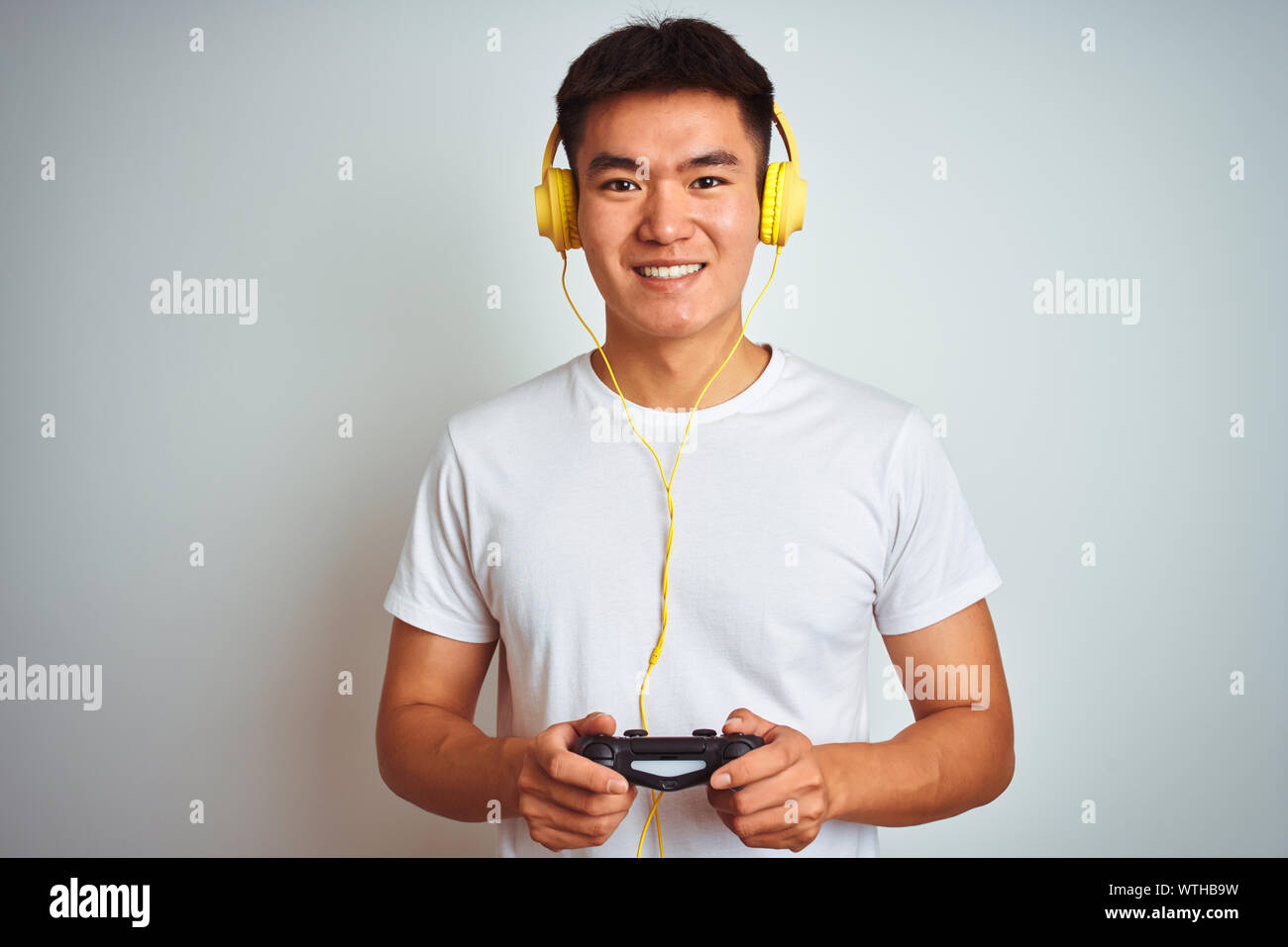 Young asian chinese gamer man playing video game standing over isolated ...