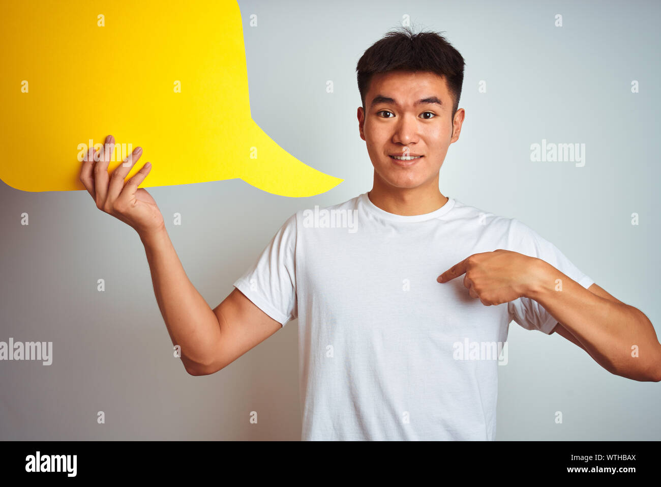Asian chinese man holding speech bubble standing over isolated white ...