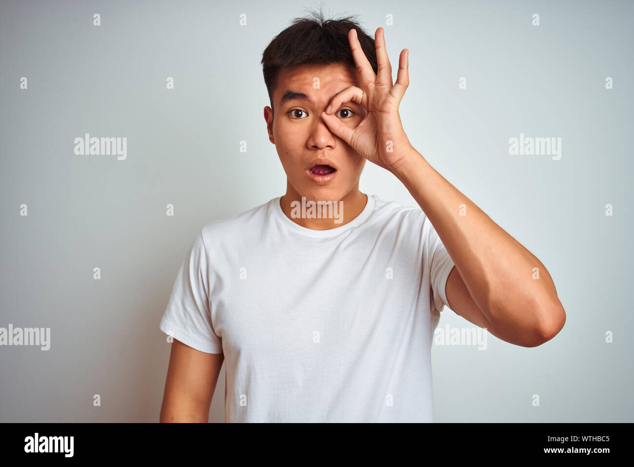 Young Asian Chinese Man Wearing T Shirt Standing Over Isolated White