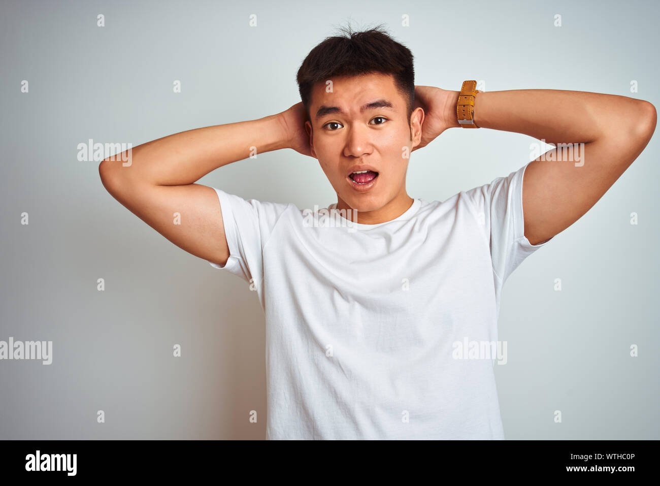 Young asian chinese man wearing t-shirt standing over isolated white ...