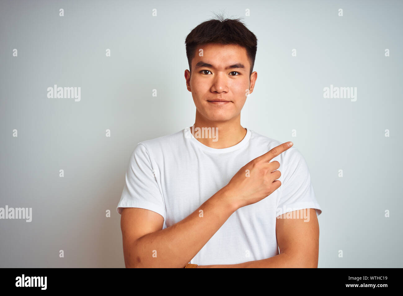 Young Asian Chinese Man Wearing T Shirt Standing Over Isolated White