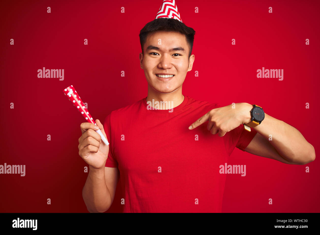 Asian chinese man on birthday celebration wearing funny hat over ...