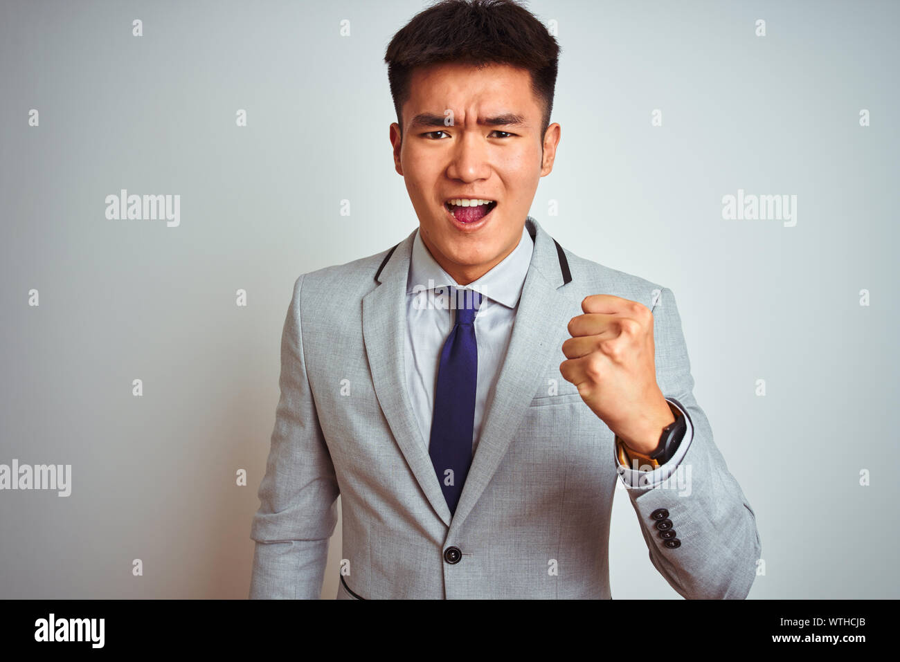 Asian chinese businessman wearing grey jacket and tie standing over ...