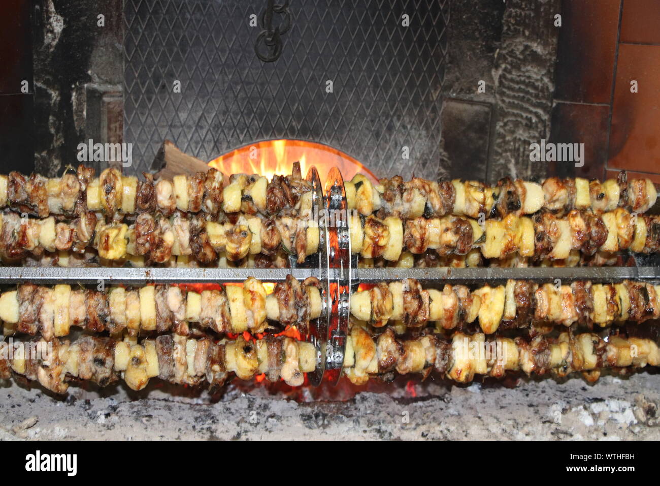 Roasted meat on spit grilled over fire Stock Photo - Alamy