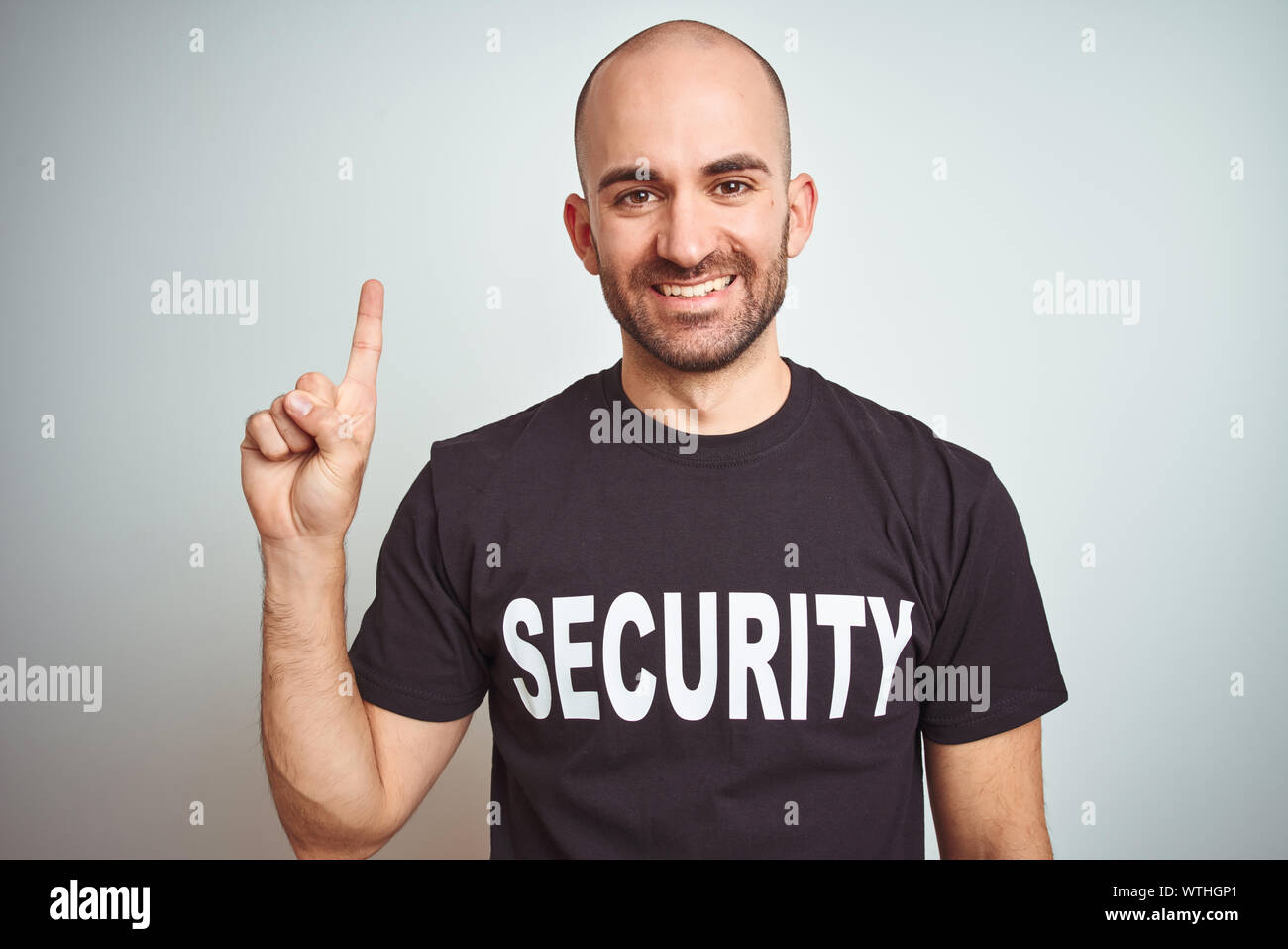 Young safeguard man wearing security uniform over isolated background ...