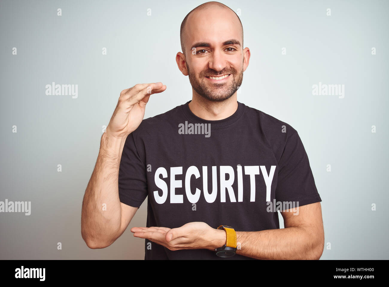 Young safeguard man wearing security uniform over isolated background ...