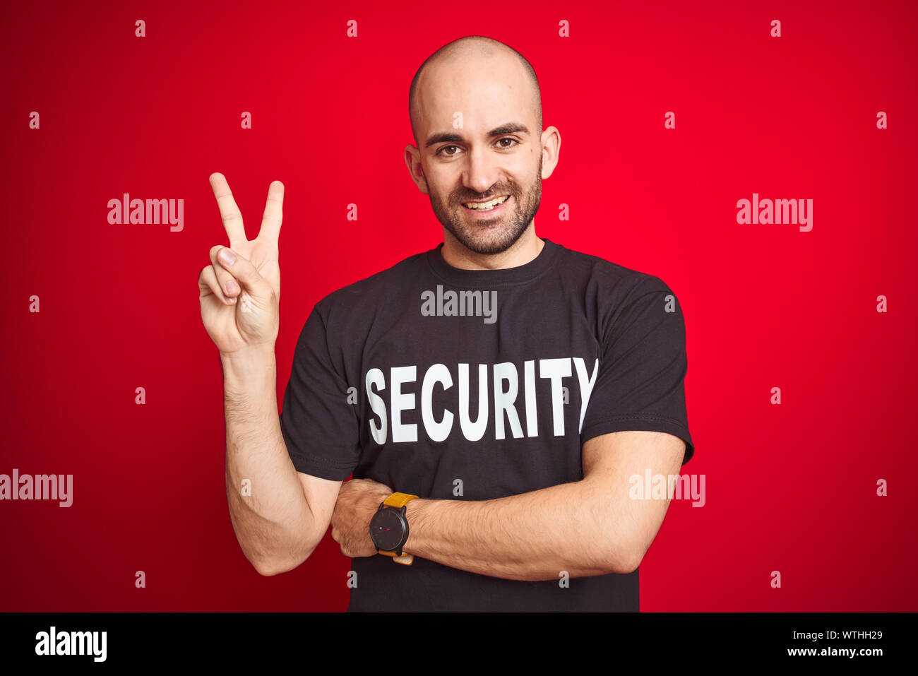 Young safeguard man wearing security uniform over red isolated ...