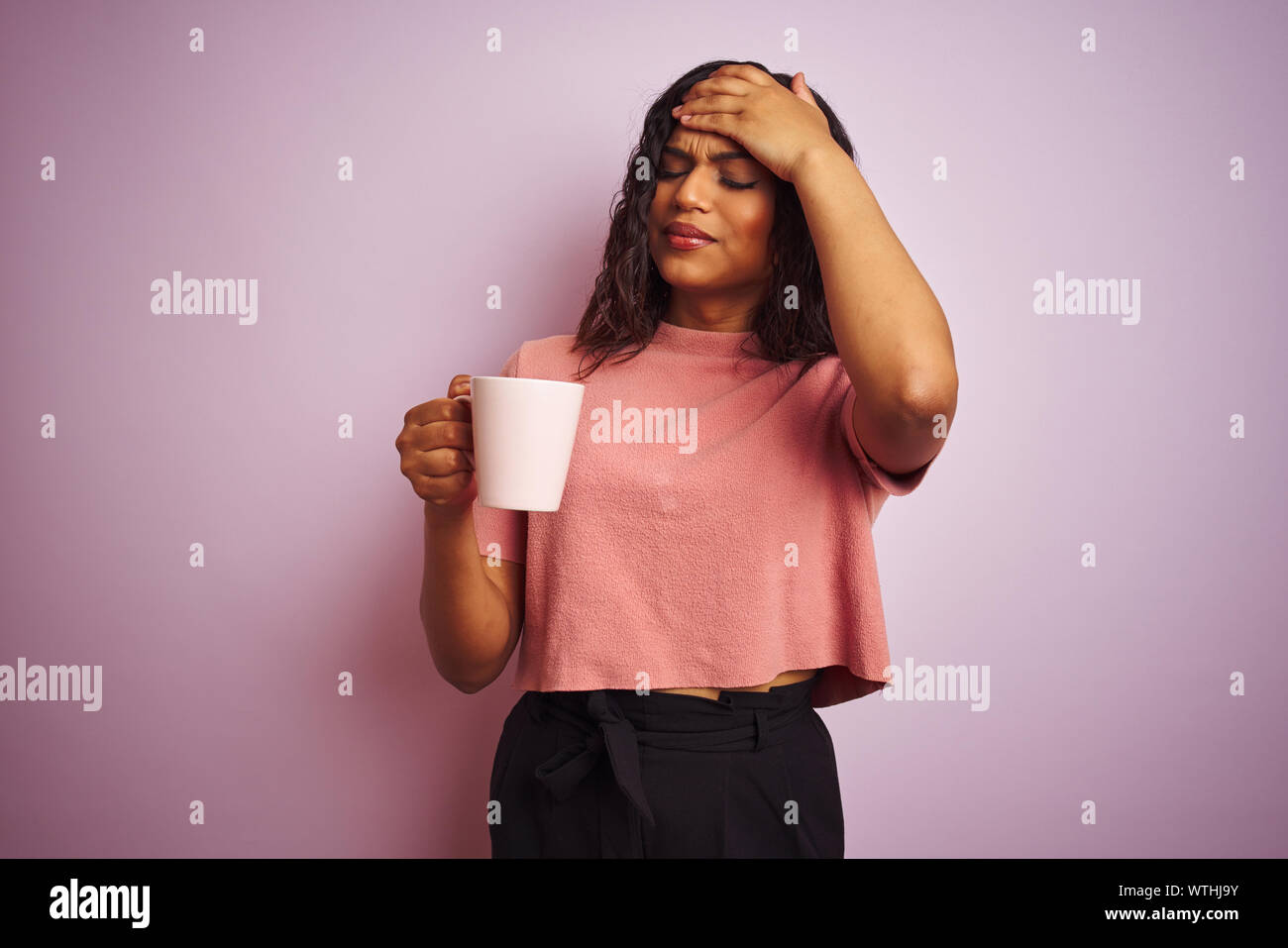 Transsexual transgender woman drinking cup of coffee over isolated pink ...