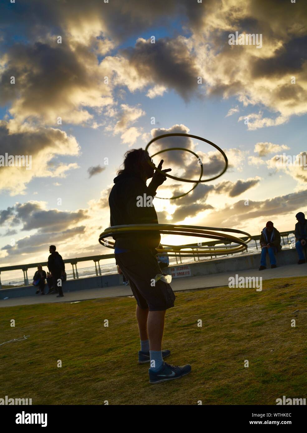 Man practicing spinning rings hoops in park, with bohemian, hippie ...