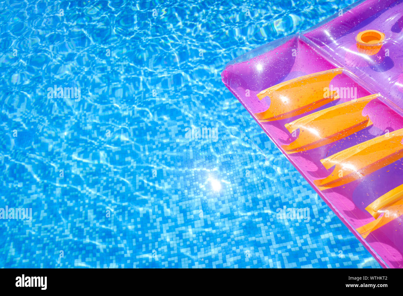 Transparent water from a pool, background with summer colored floats ...