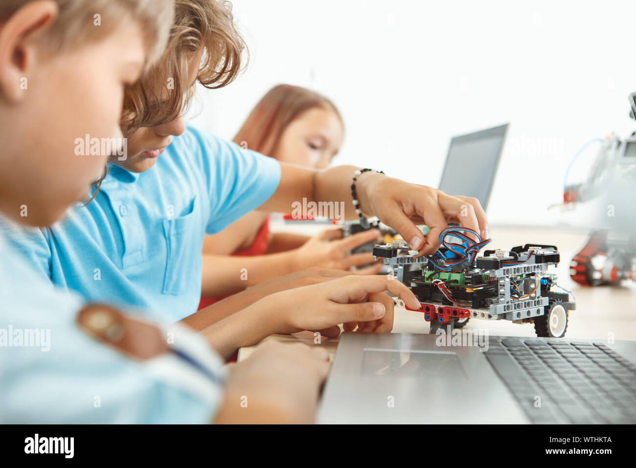 Robotics. Children having class fixing robots cooperating close-up ...