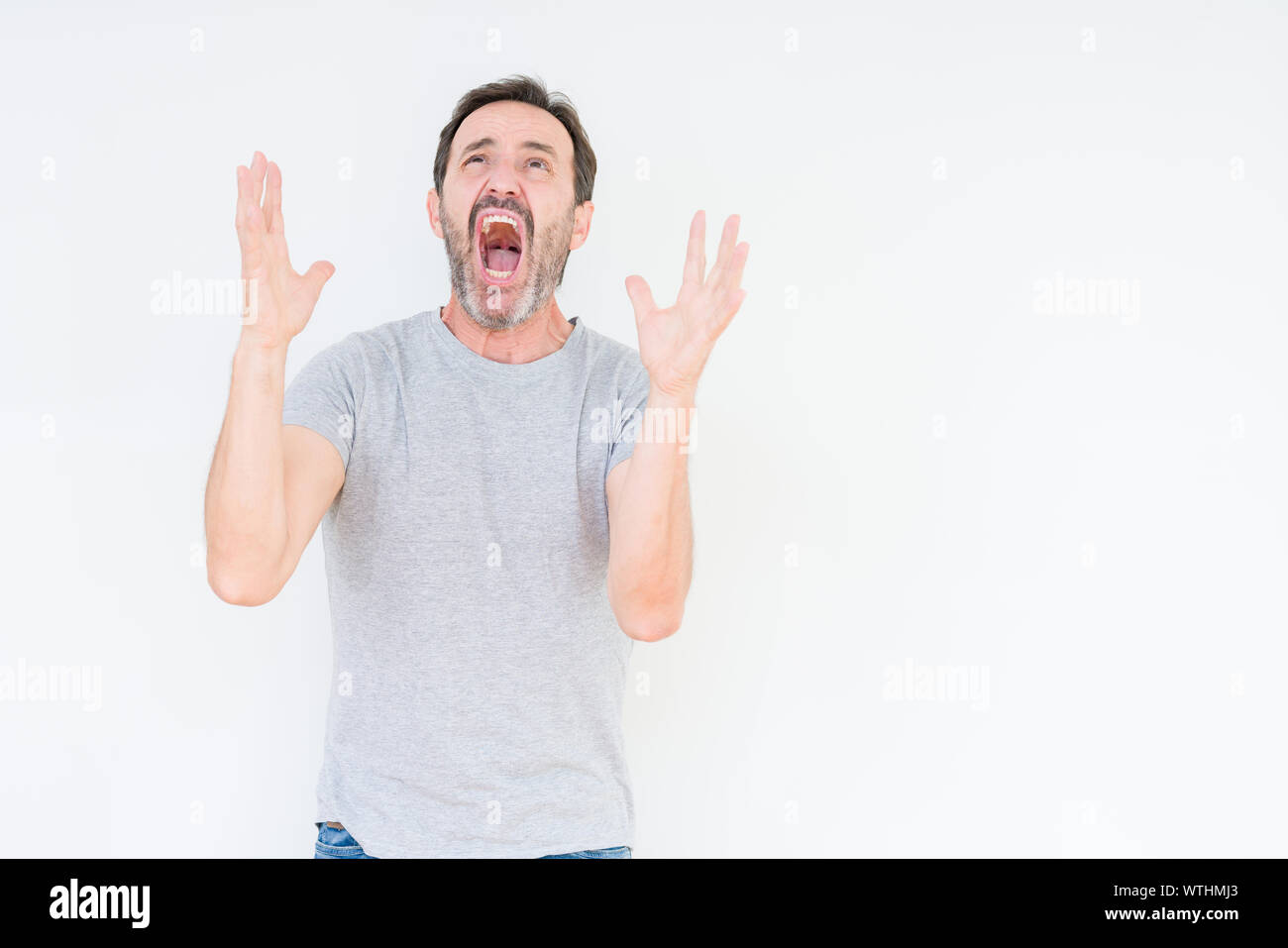 Handsome senior man over isolated background crazy and mad shouting and ...