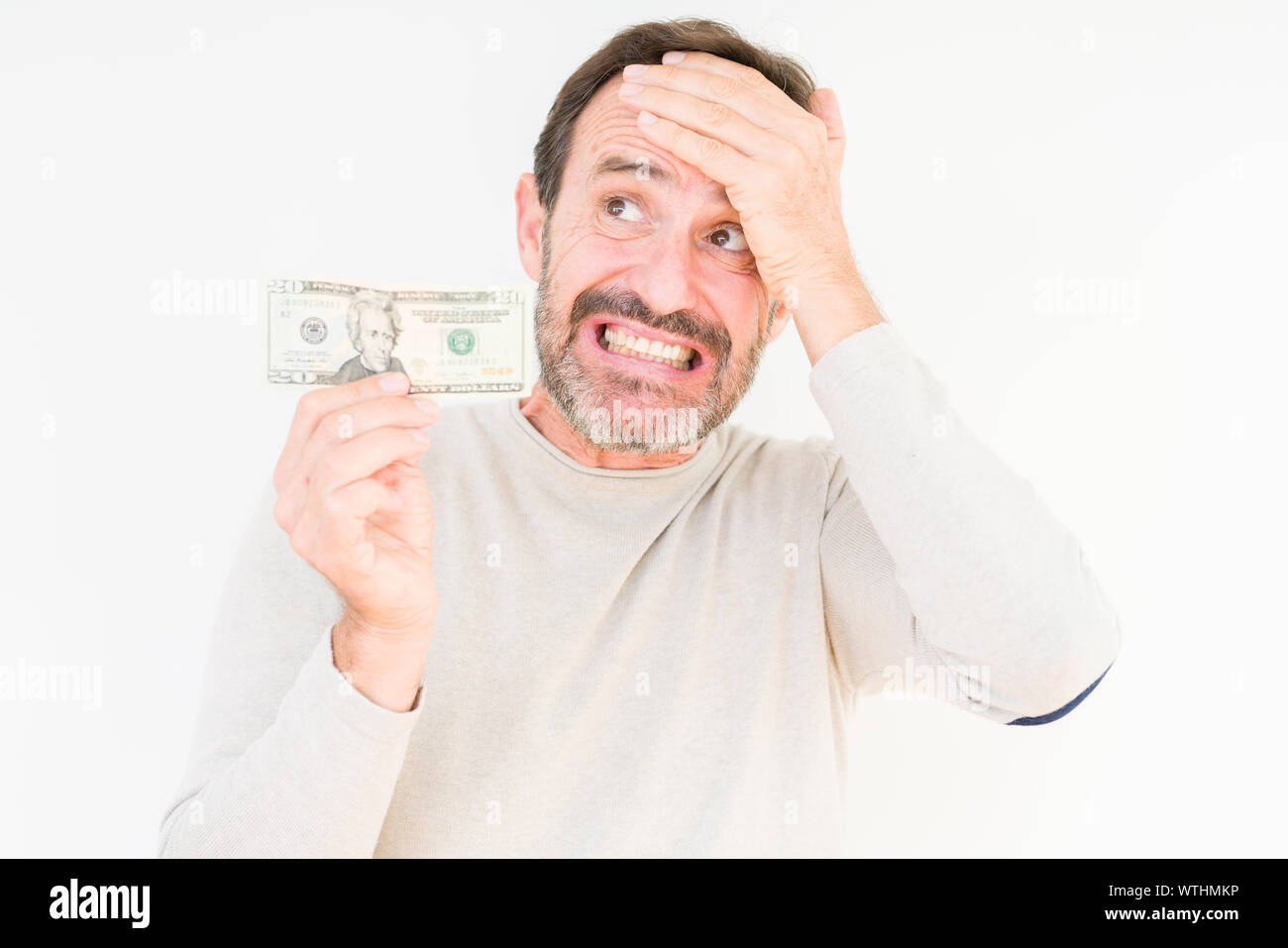 Senior man holding twenty dollars bank note over isolated background ...