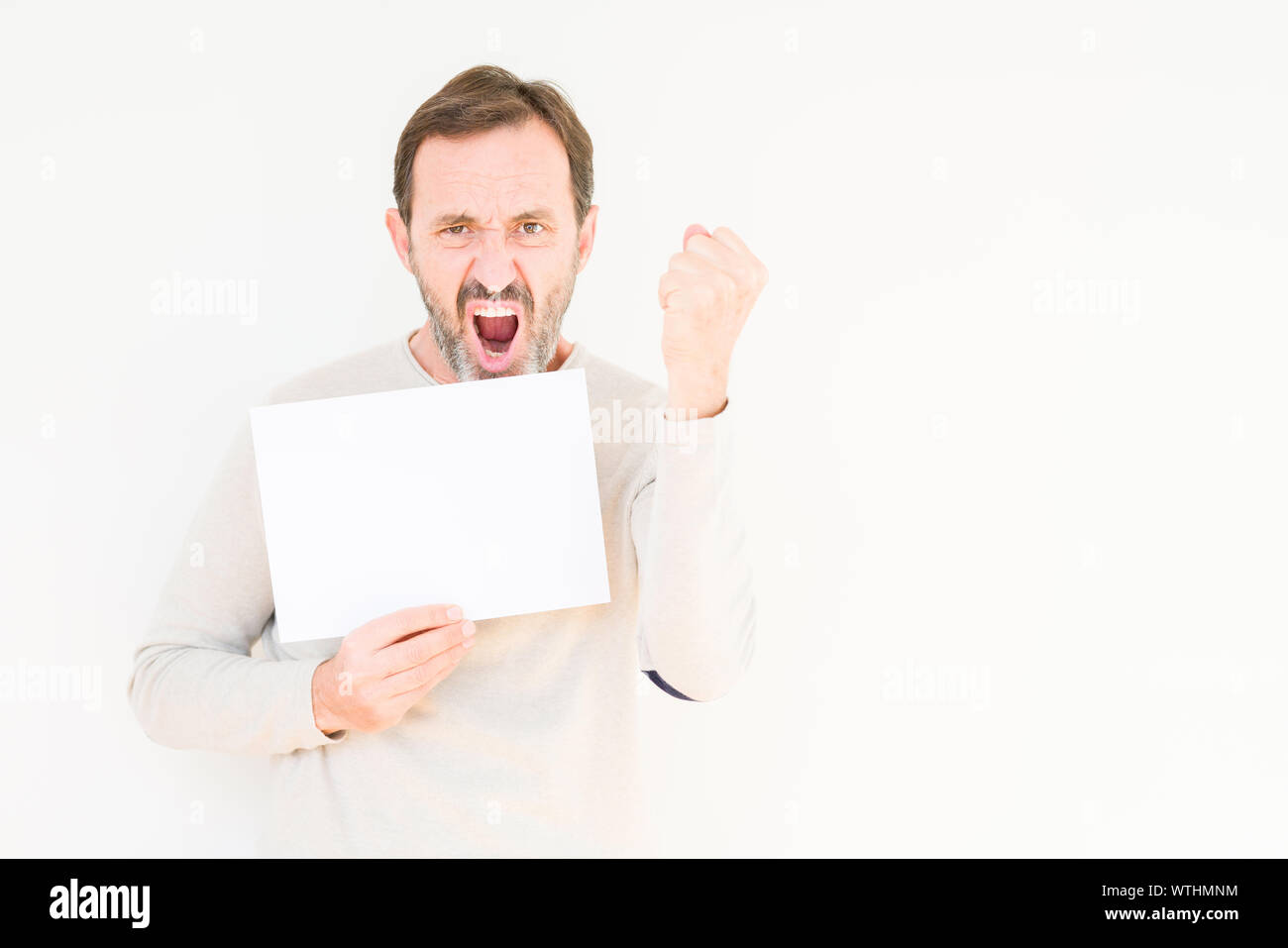 Senior man holding blank paper sheet over isolated background annoyed ...