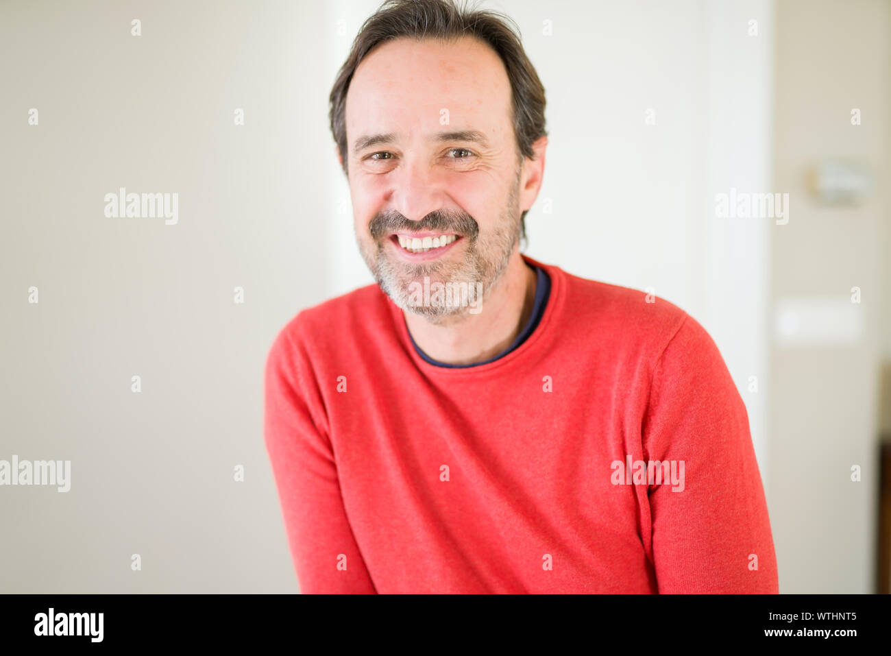 Handsome middle age man smiling looking at the camera at home Stock ...