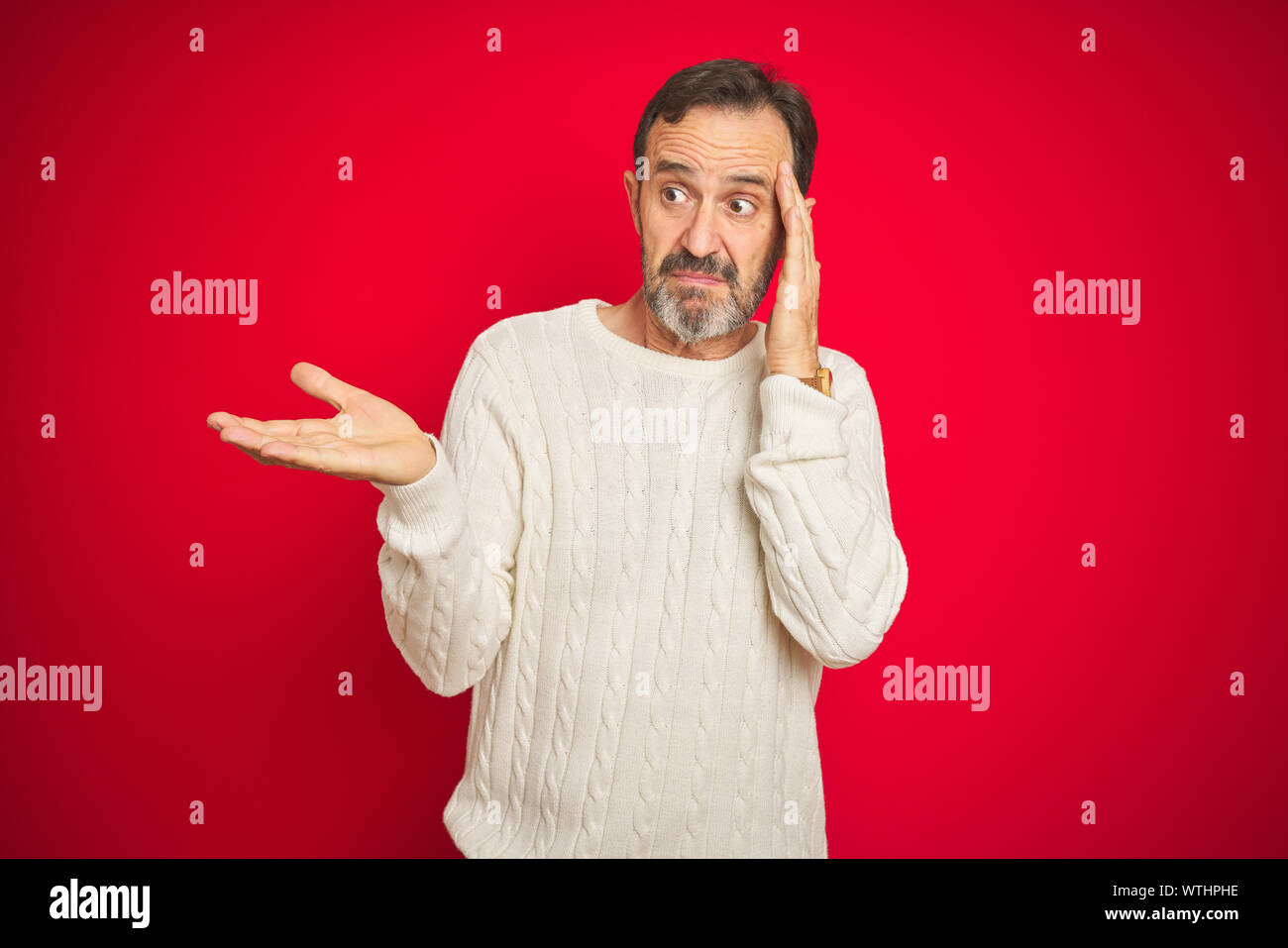 Handsome middle age senior man with grey hair over isolated red ...