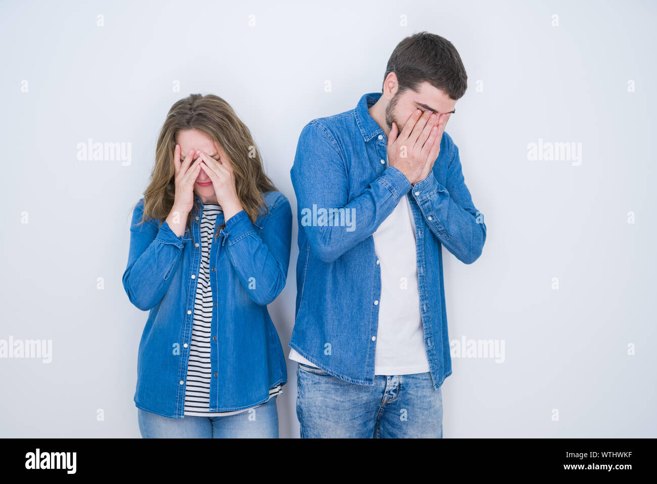 Young beautiful couple standing together over white isolated background ...