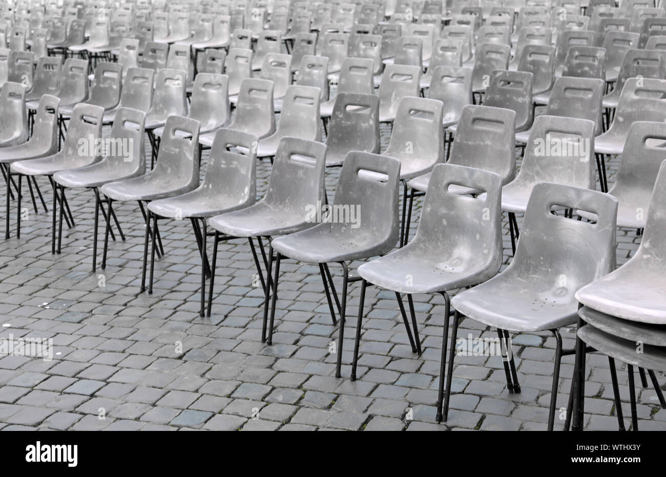 many empty gray chairs set up in St. Peter Square for the mass of the ...