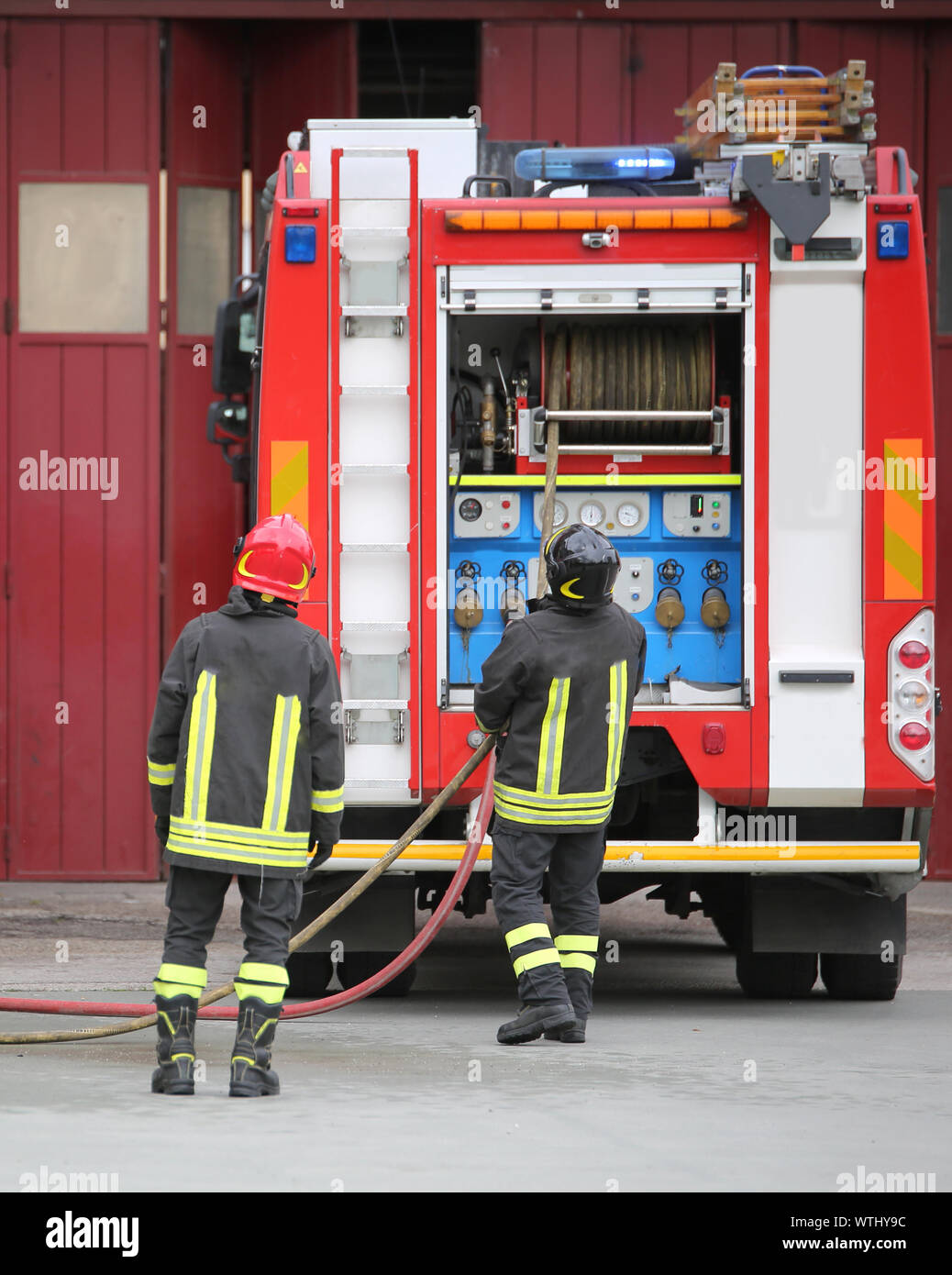 two firefighters and the fire turck during an emergency on the city ...