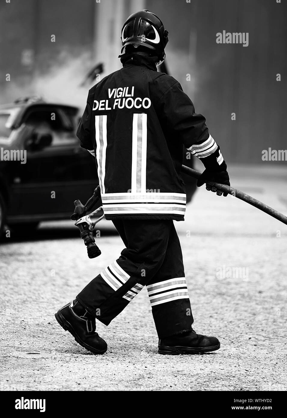 italian firefighter with uniform and helmet and a broken car after the ...