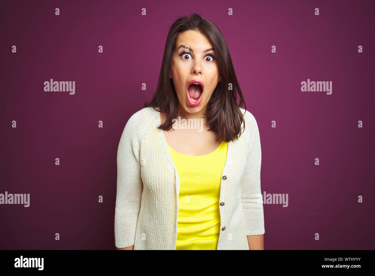Young beautiful brunette woman a jacket over purple isolated background ...