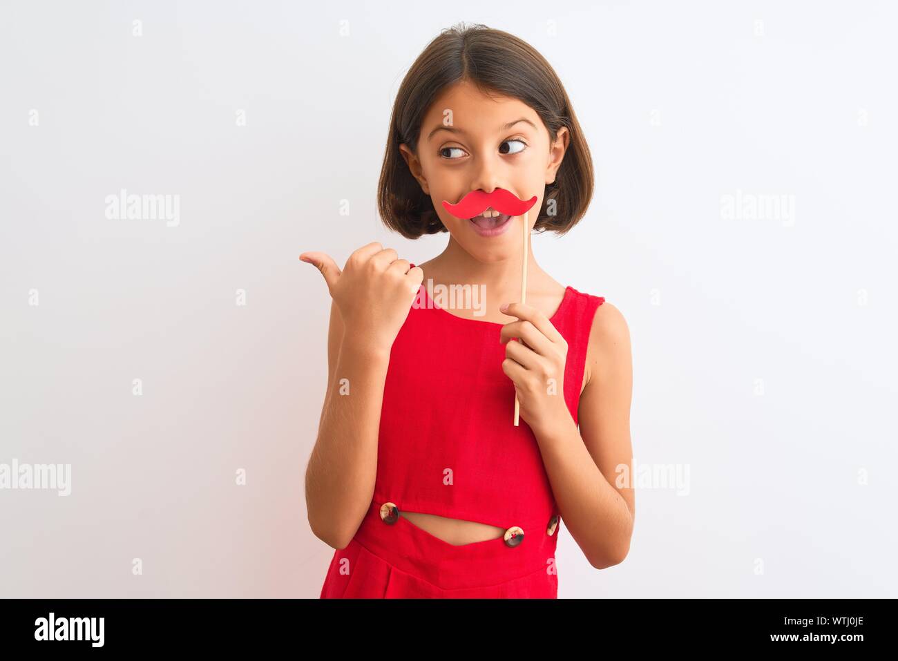 Beautiful child girl holding fanny party mustache standing over ...
