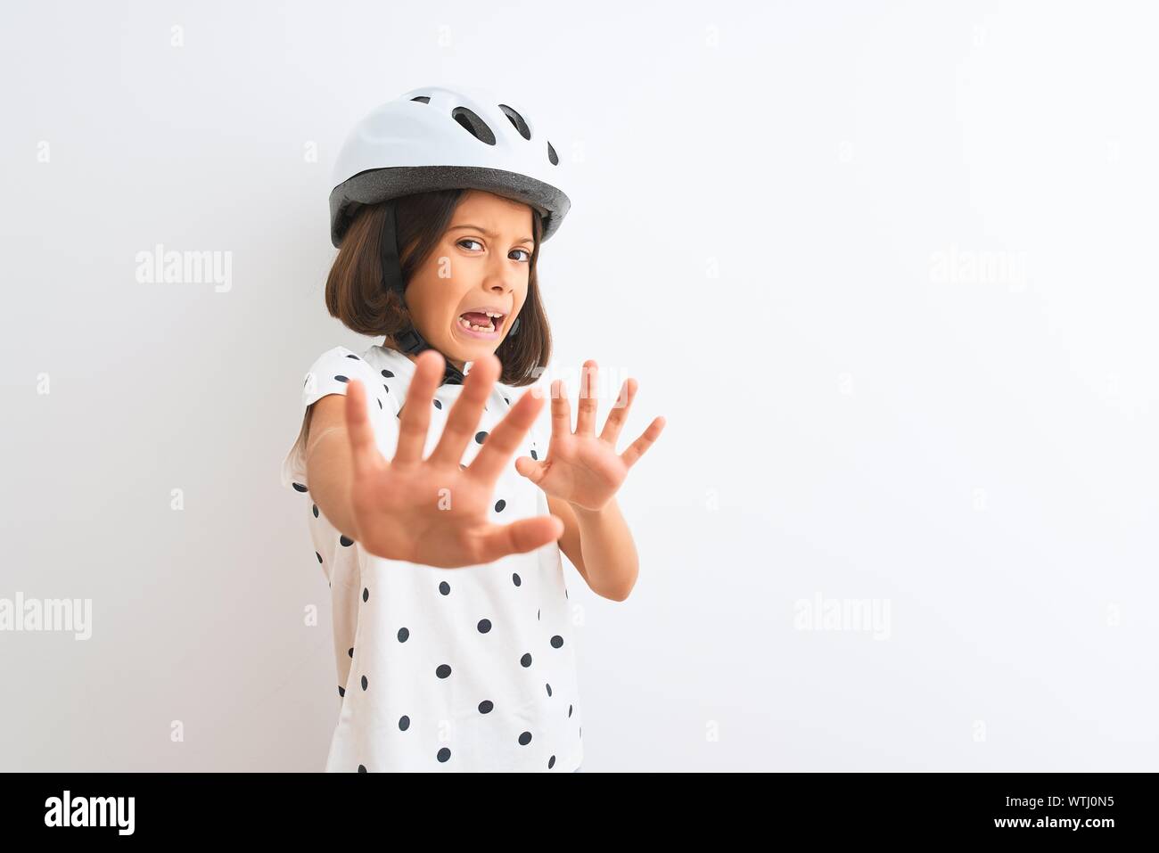 Beautiful child girl wearing security bike helmet standing over ...