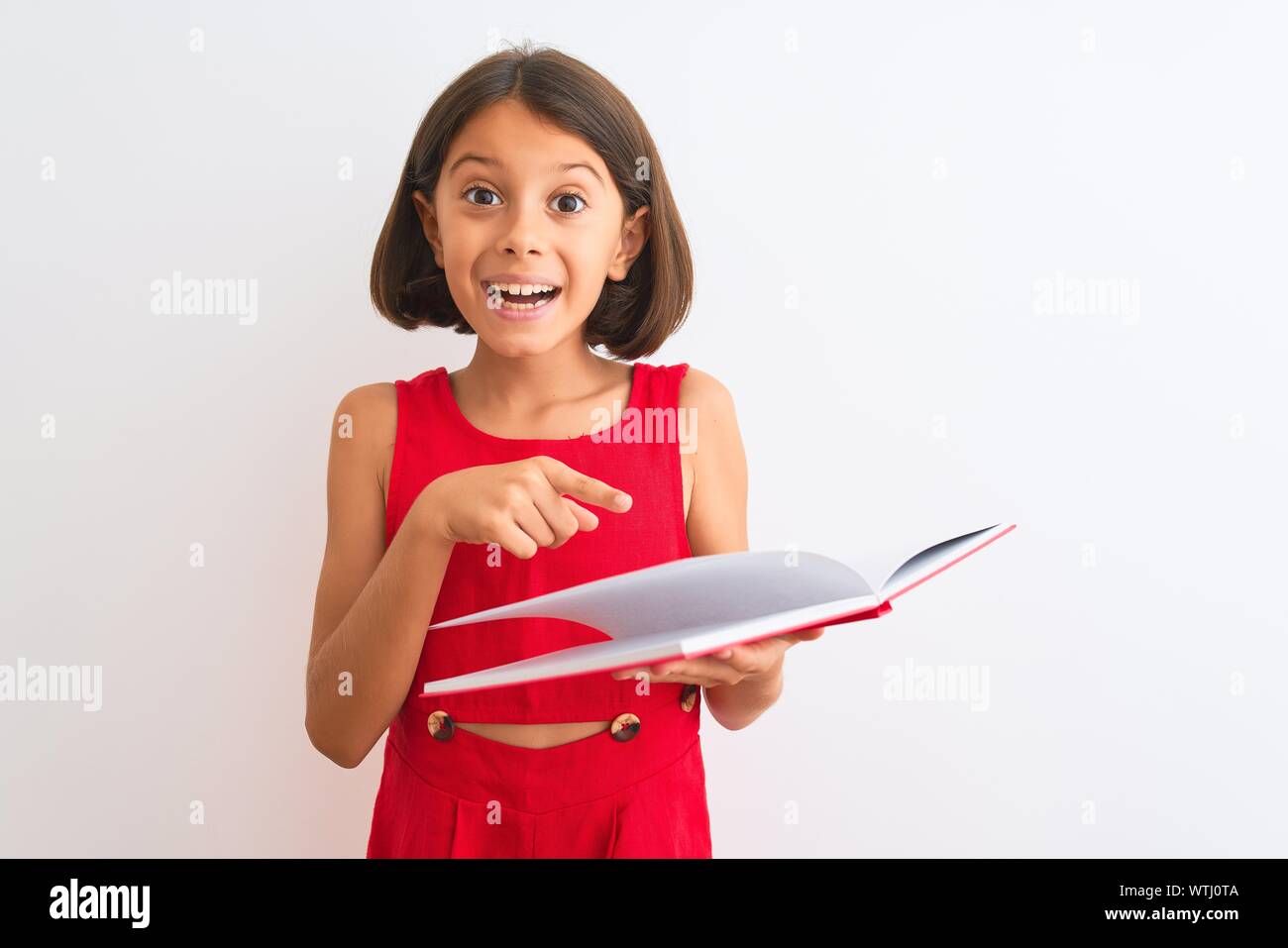 Beautiful student child girl reading red book standing over isolated ...