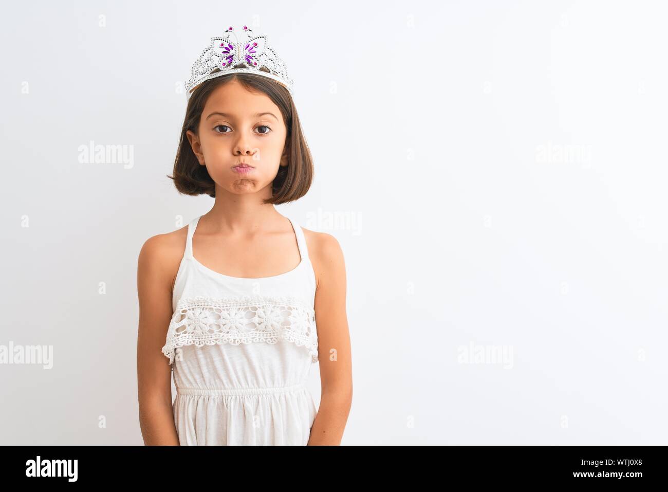 Beautiful child girl wearing princess crown standing over isolated ...