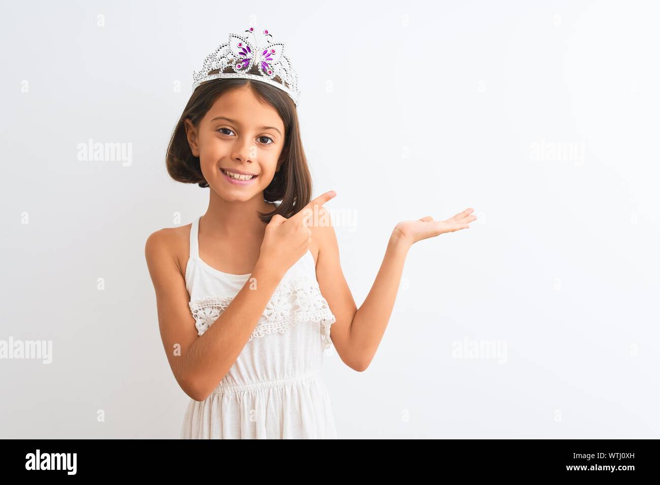 Beautiful child girl wearing princess crown standing over isolated ...