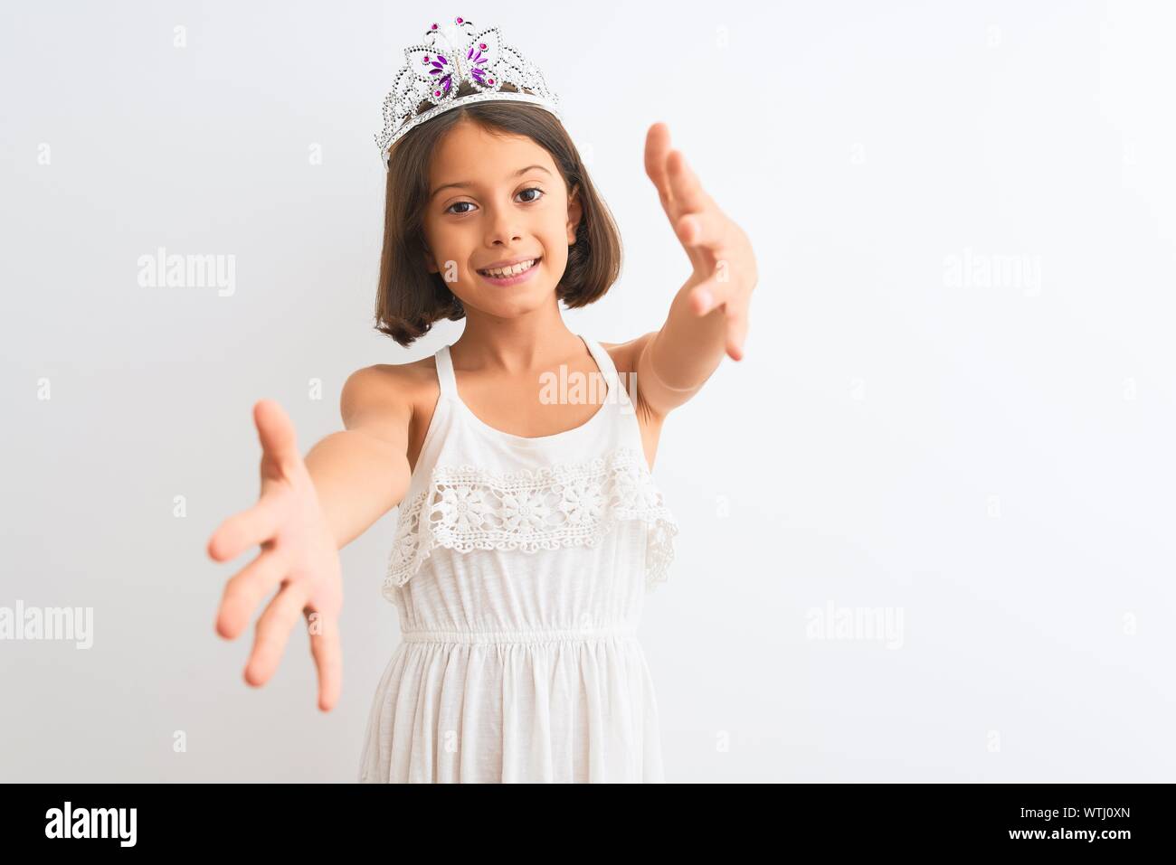 Beautiful child girl wearing princess crown standing over isolated ...