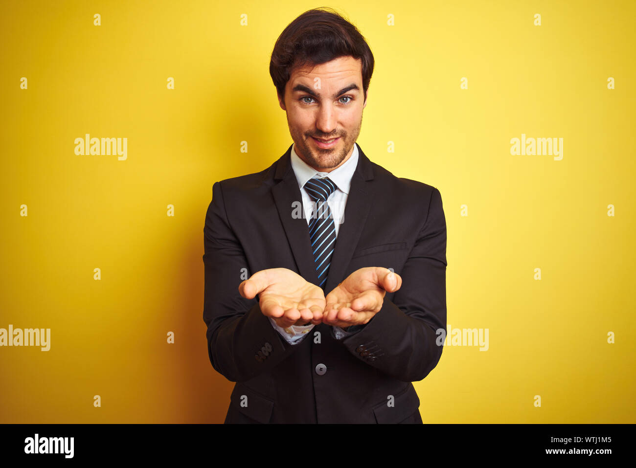 Young handsome businessman wearing suit and tie standing over isolated ...