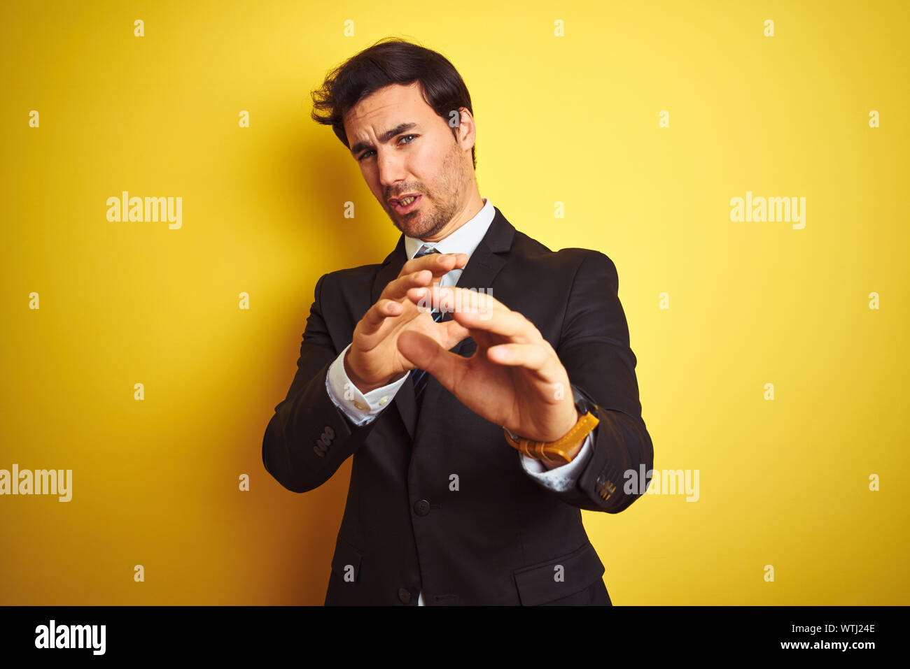 Young handsome businessman wearing suit and tie standing over isolated ...
